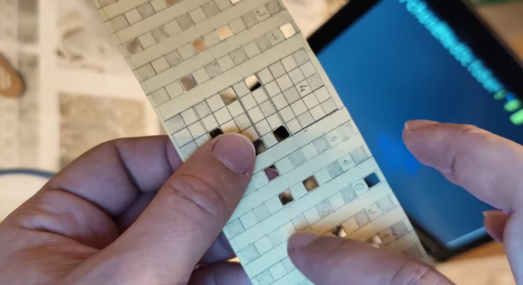 Punch card-controlled computer says 'Let there be light!'